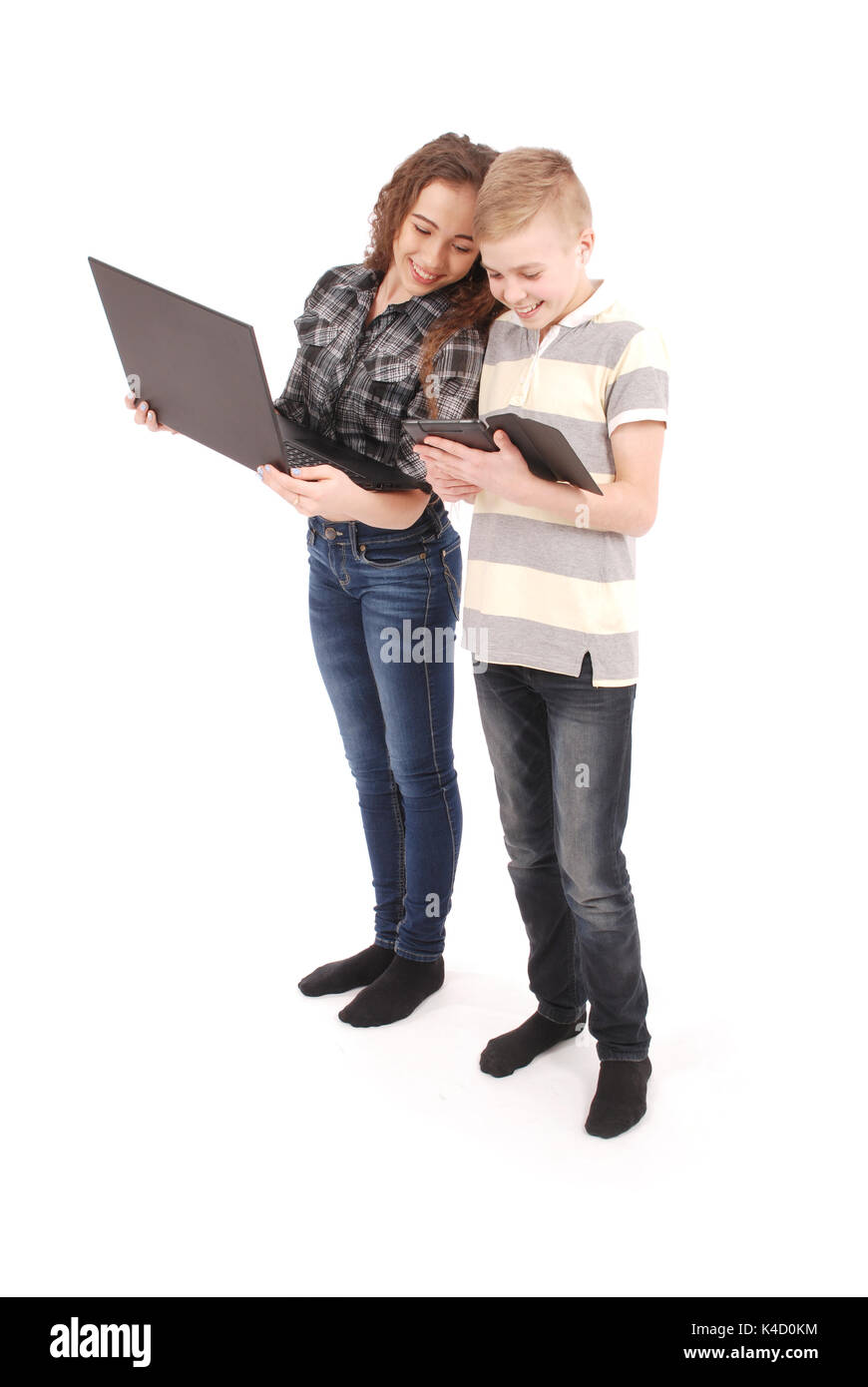 Two kids playing and surfing the web on digital tablet and laptop ...