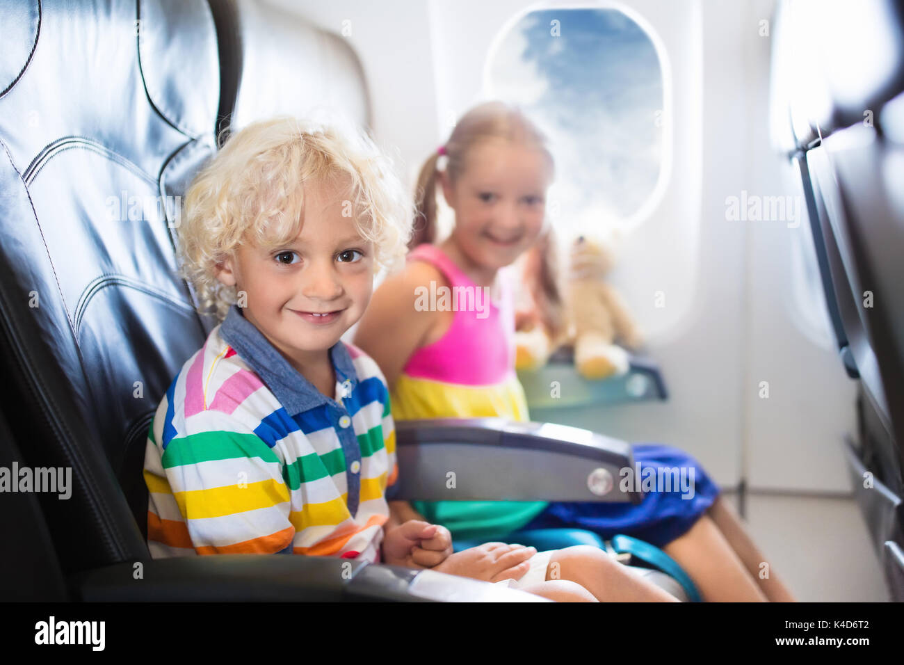 Child in airplane. Kids sit in air plane window seat. Flight ...