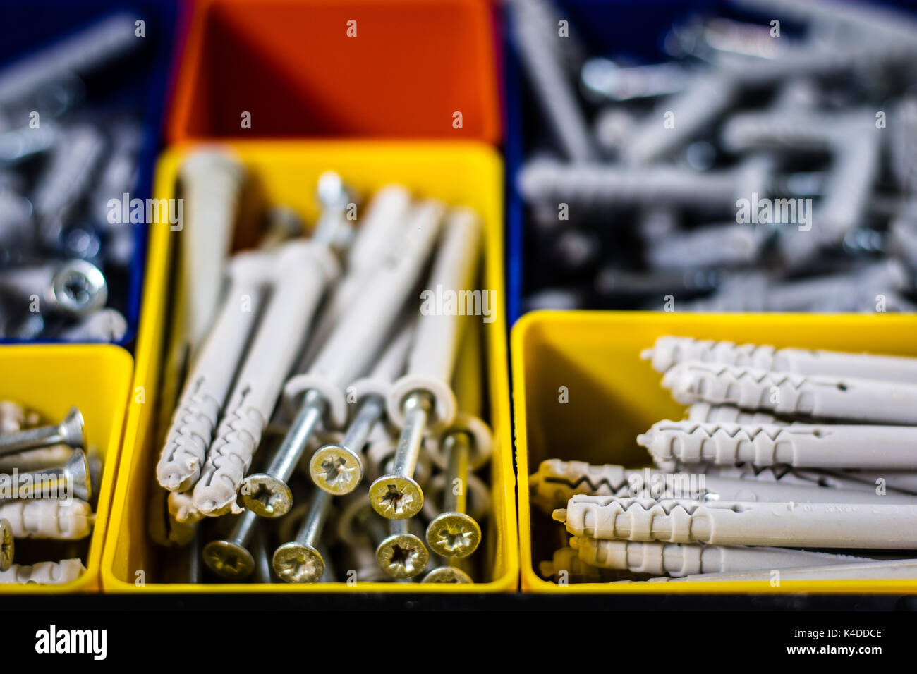 Screws segregated in plastic colored containers. Box for builder and ...