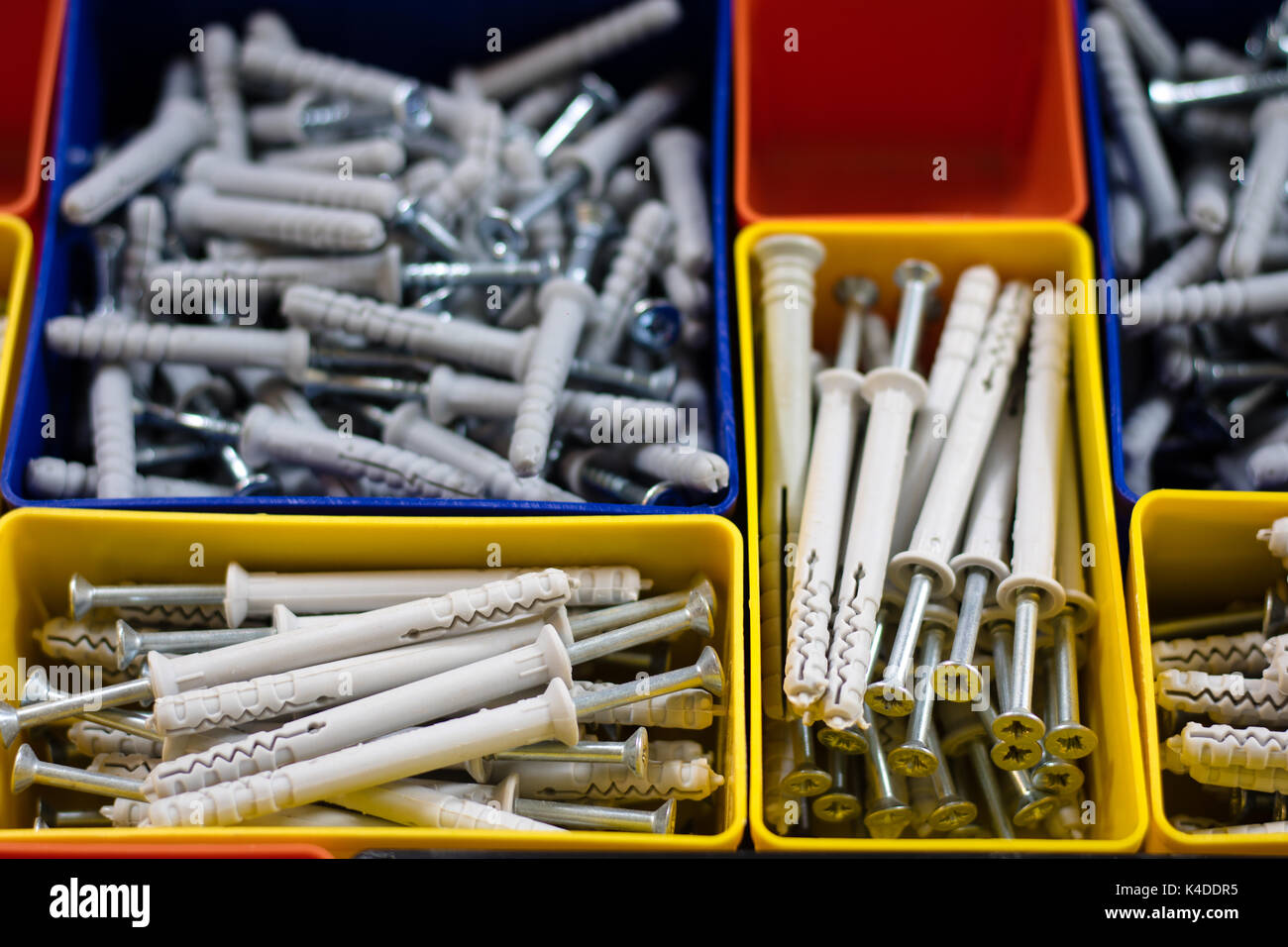 Screws segregated in plastic colored containers. Box for builder and ...