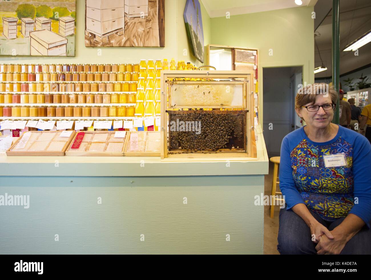 A beekeeper sits next to a hive of bees on display at the Minnesota ...