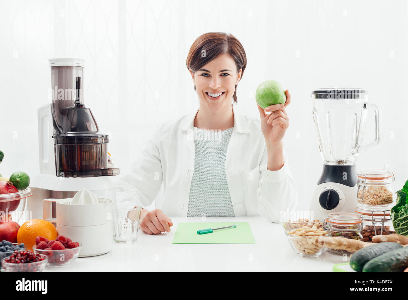 Smiling professional nutritionist holding an apple, she has healthy ...