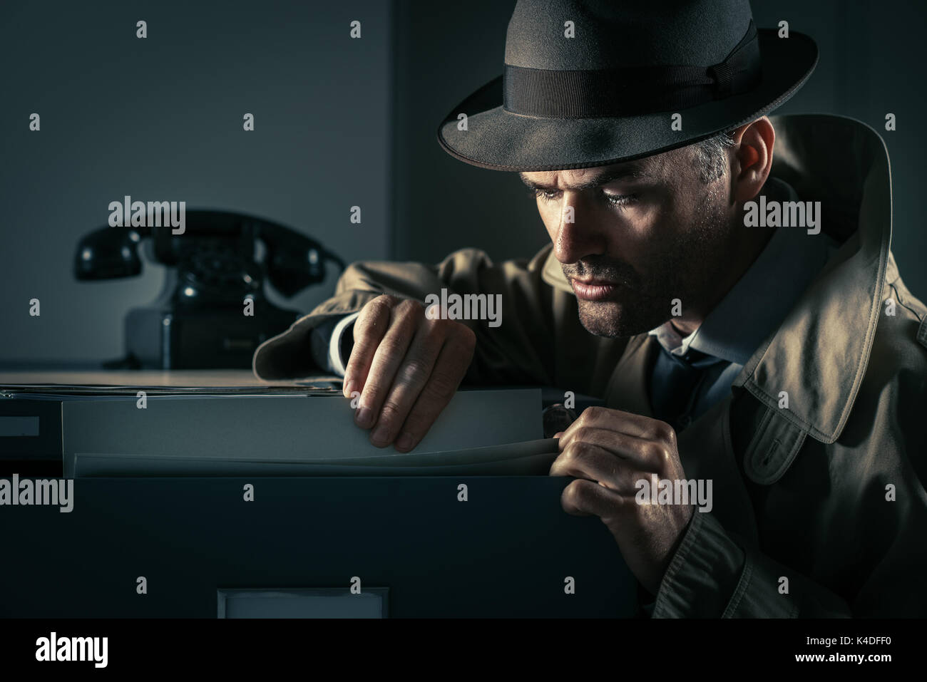 Vintage undercover criminal spy stealing files in a filing cabinet late ...