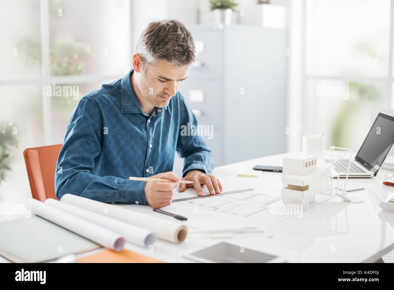 Professional architect working at office desk, he is drawing and making ...
