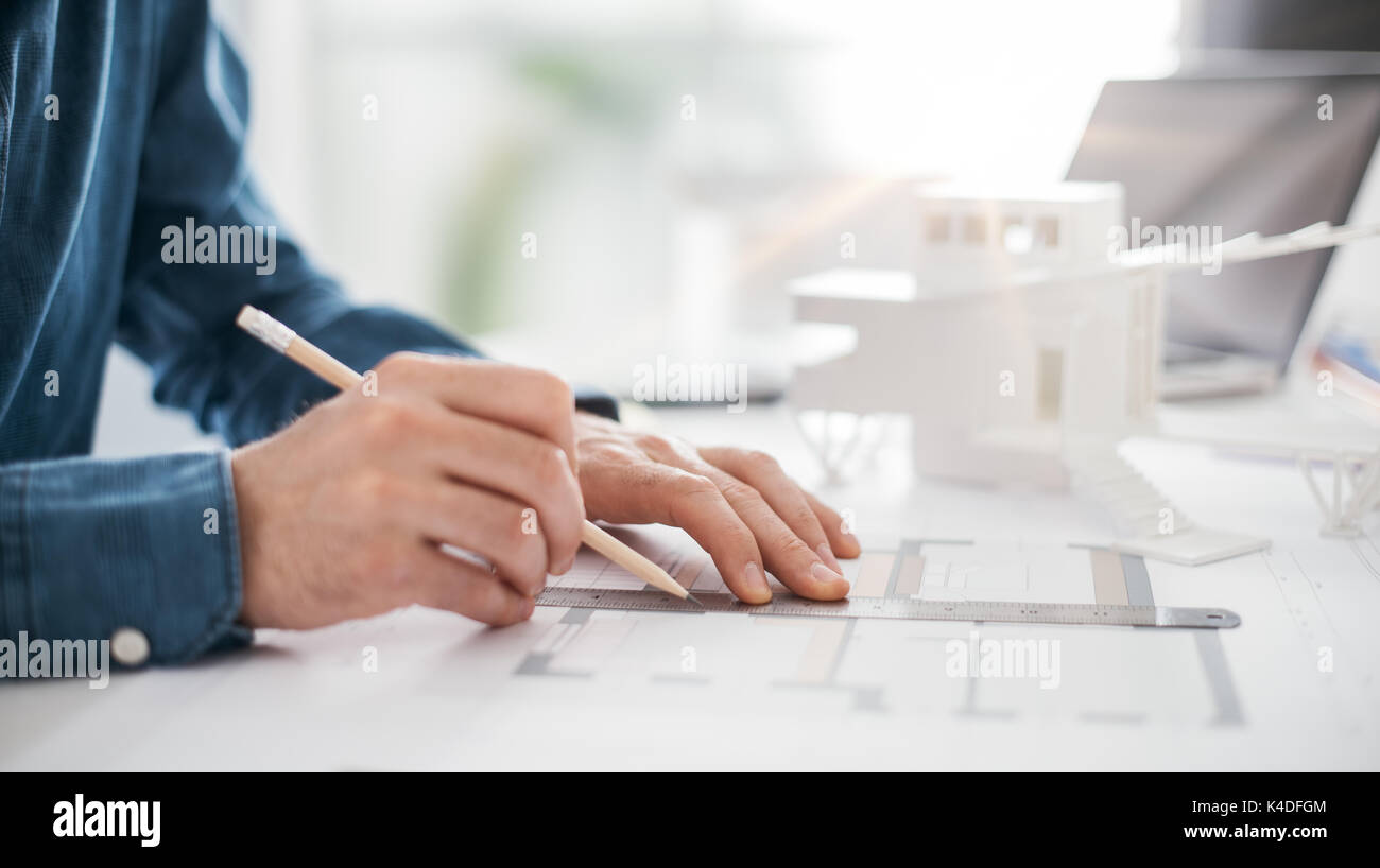 Professional architect working at office desk, he is drawing and making ...