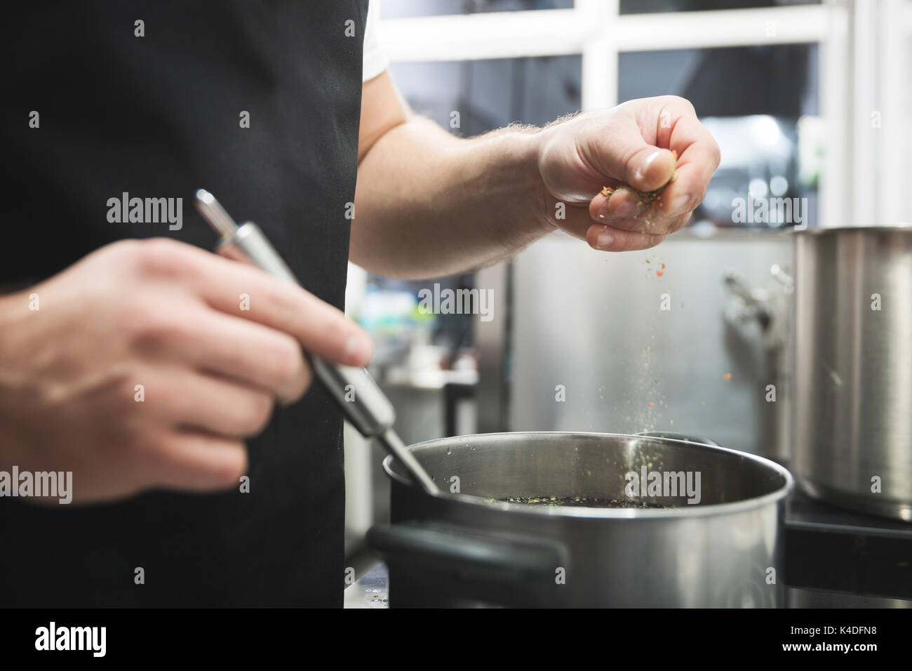 Closeup on chef hands pouring spices to the soup Stock Photo - Alamy