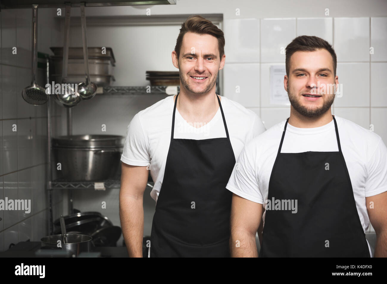 Front portrait of two happy male chef in the kitchen Stock Photo - Alamy
