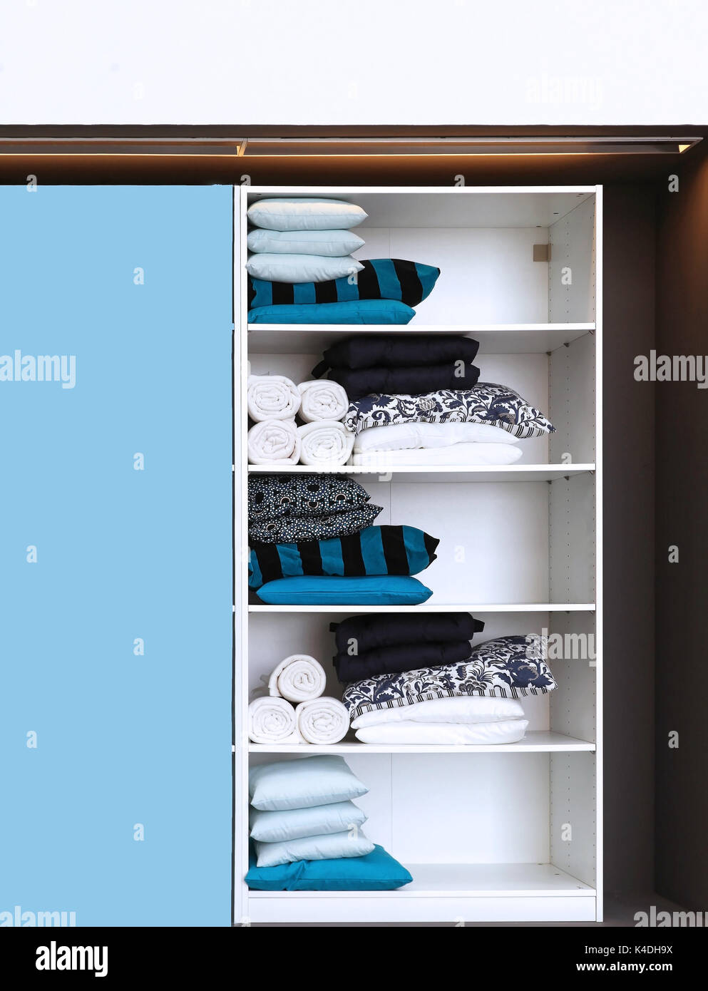 Open closet with blue color home decor textile on shelves Stock Photo ...