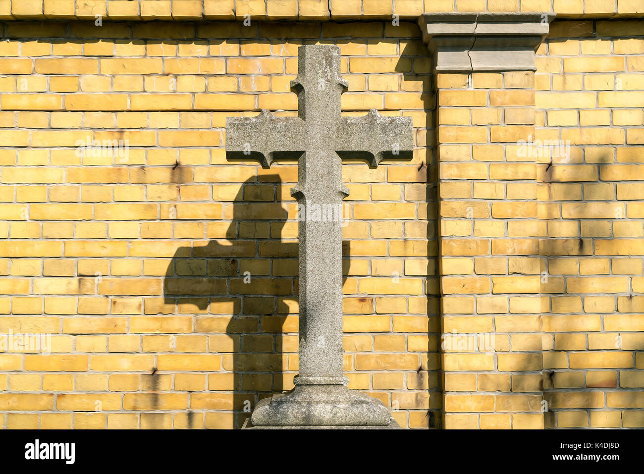 stony cross in front of a yellow brick wall Stock Photo - Alamy