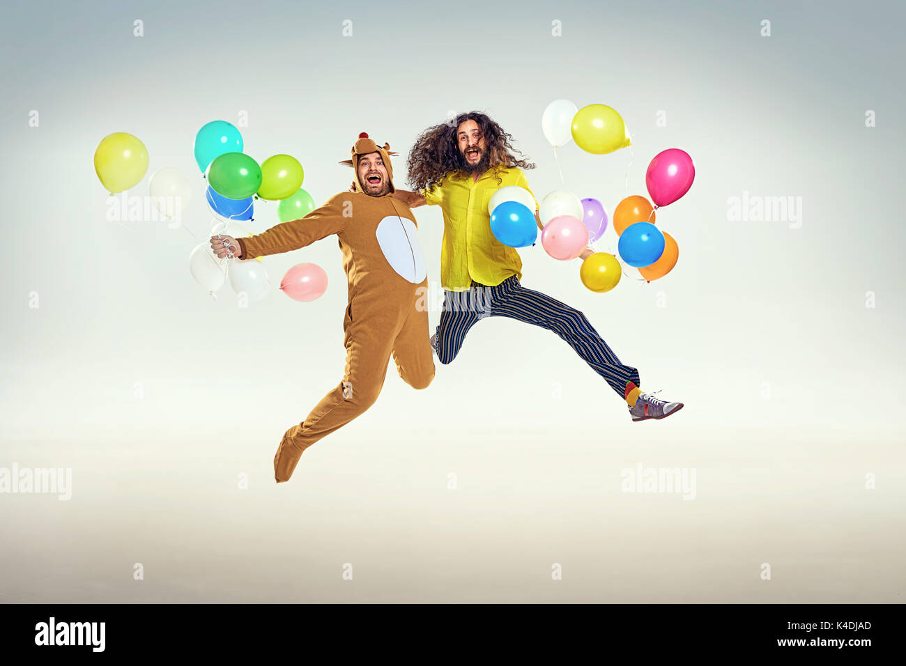 Picture presenting two funny men jumping and holding balloons Stock ...