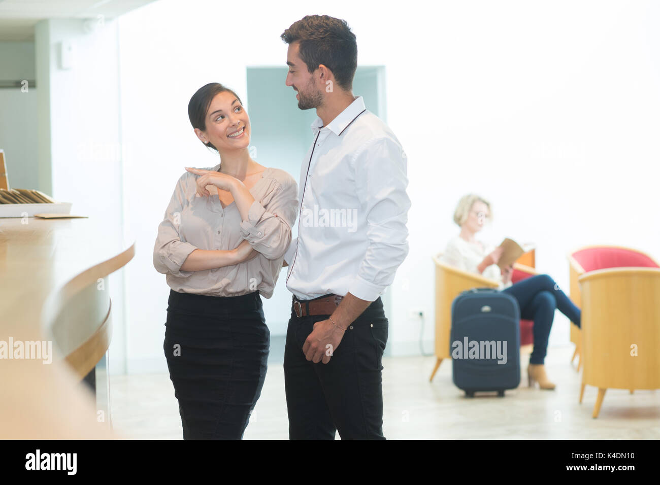 couple checking in at hotel reception smiling happy Stock Photo - Alamy