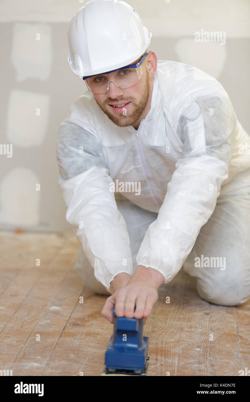 man starting to remove the old floor tiles Stock Photo - Alamy