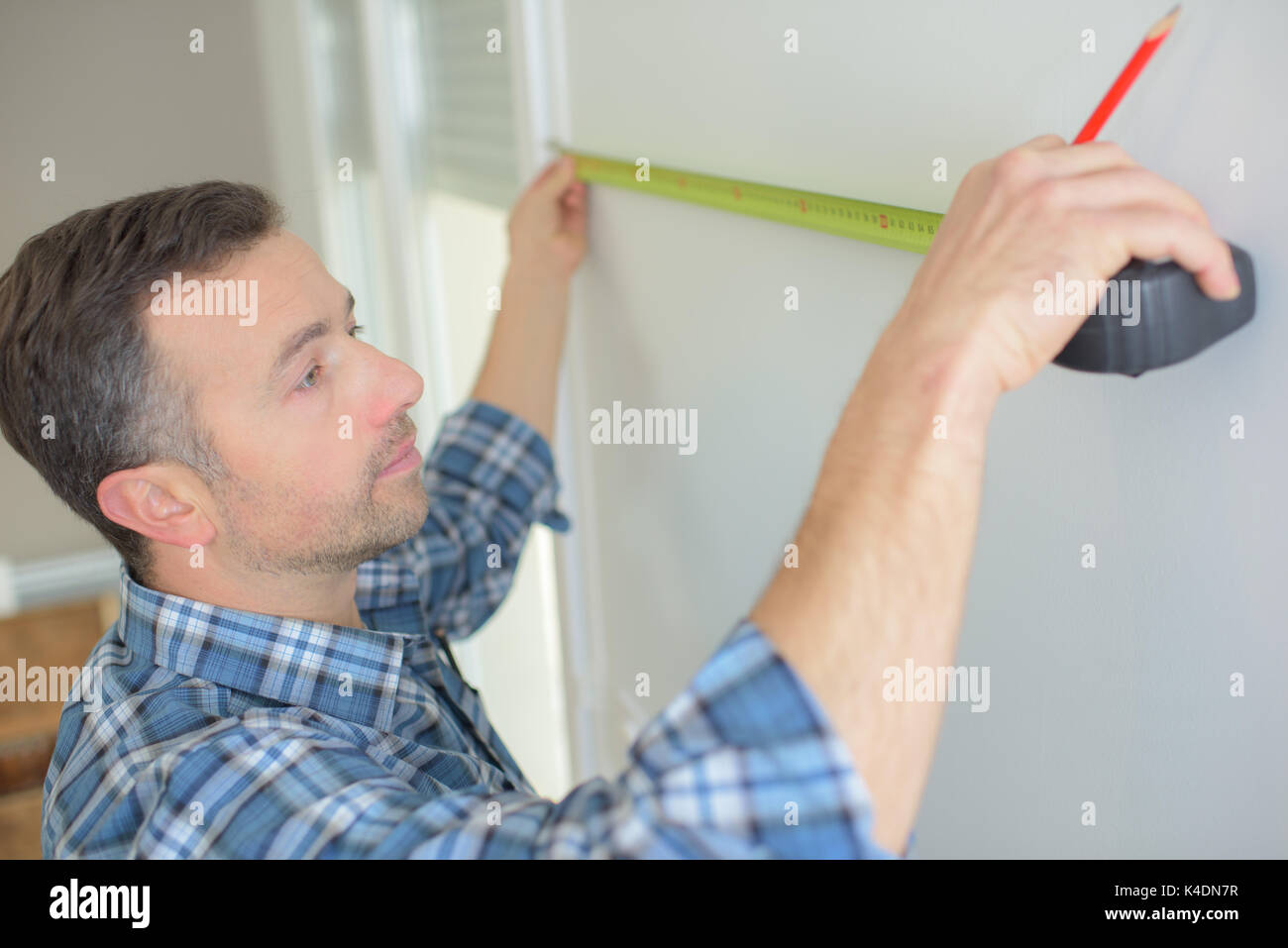 man with pencil measuring wall Stock Photo - Alamy