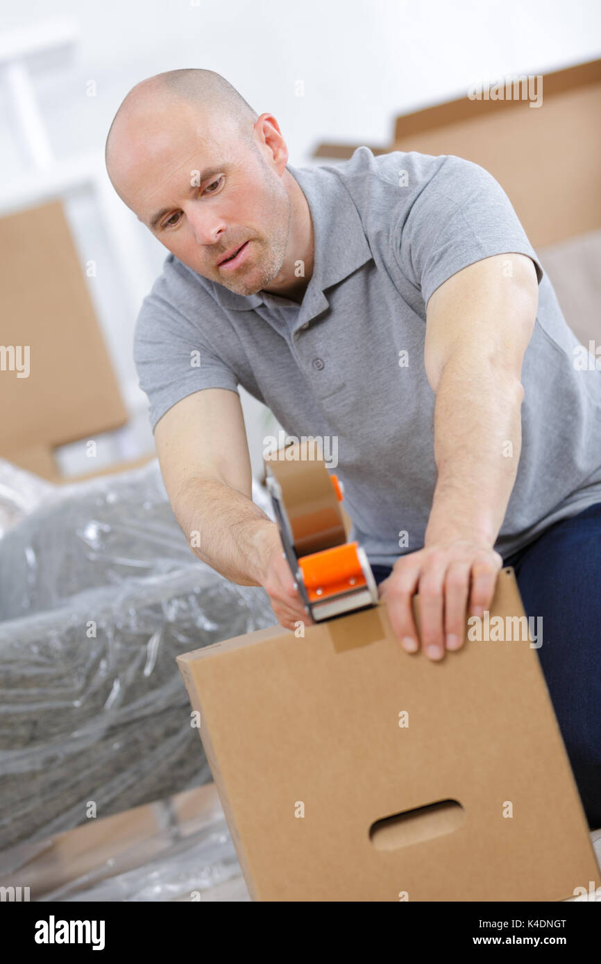 man packing things and taping boxes Stock Photo - Alamy