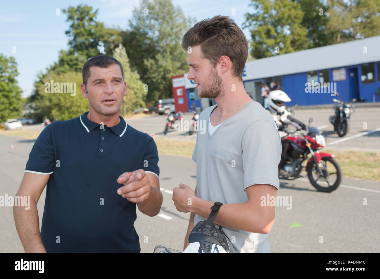 driving instructor and young man student in examination area Stock ...