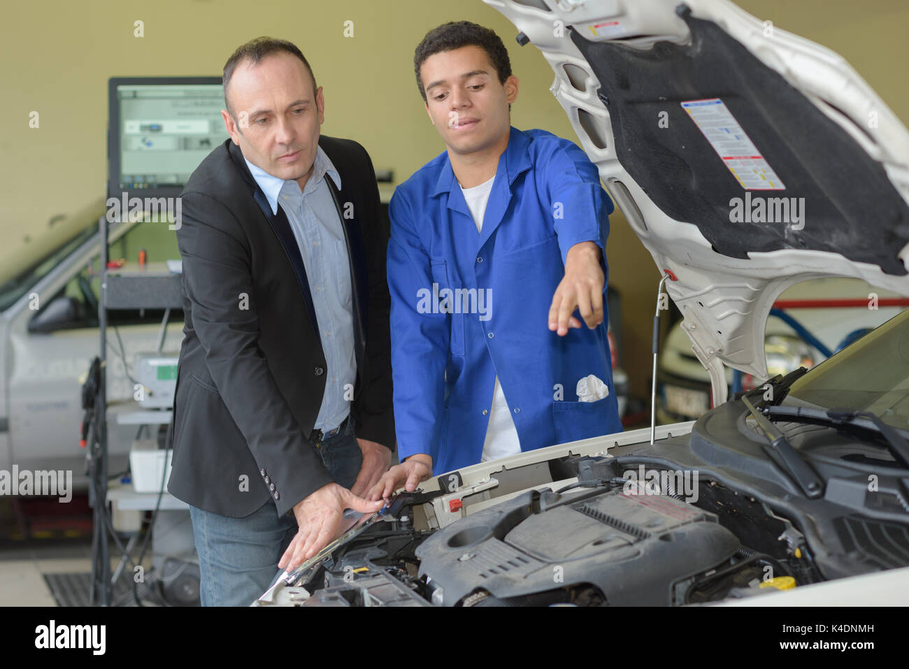 happy professional adult mechanics repairing car of client Stock Photo ...