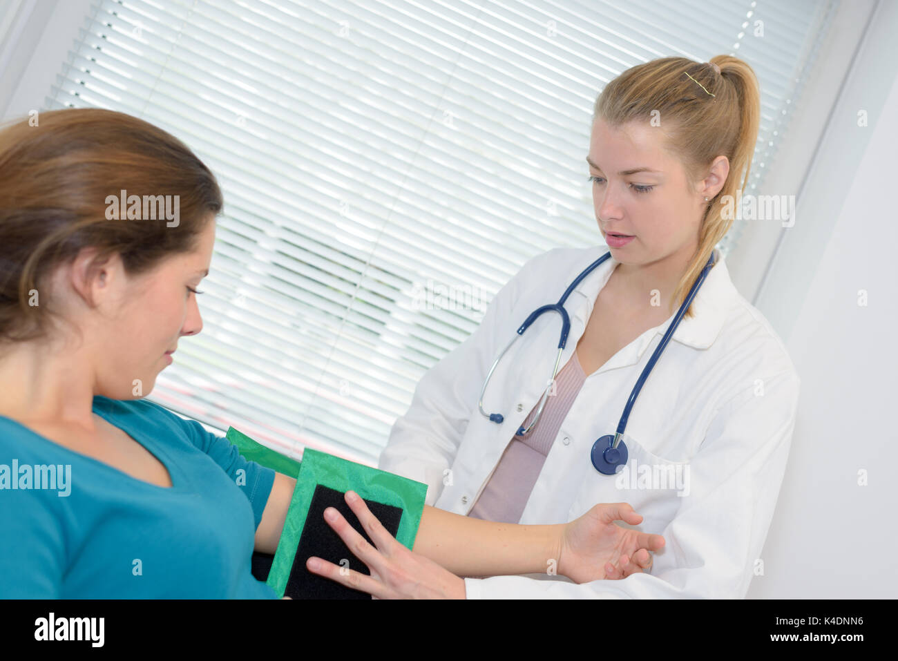 female doctor checking blood pressure of the female patient Stock Photo ...