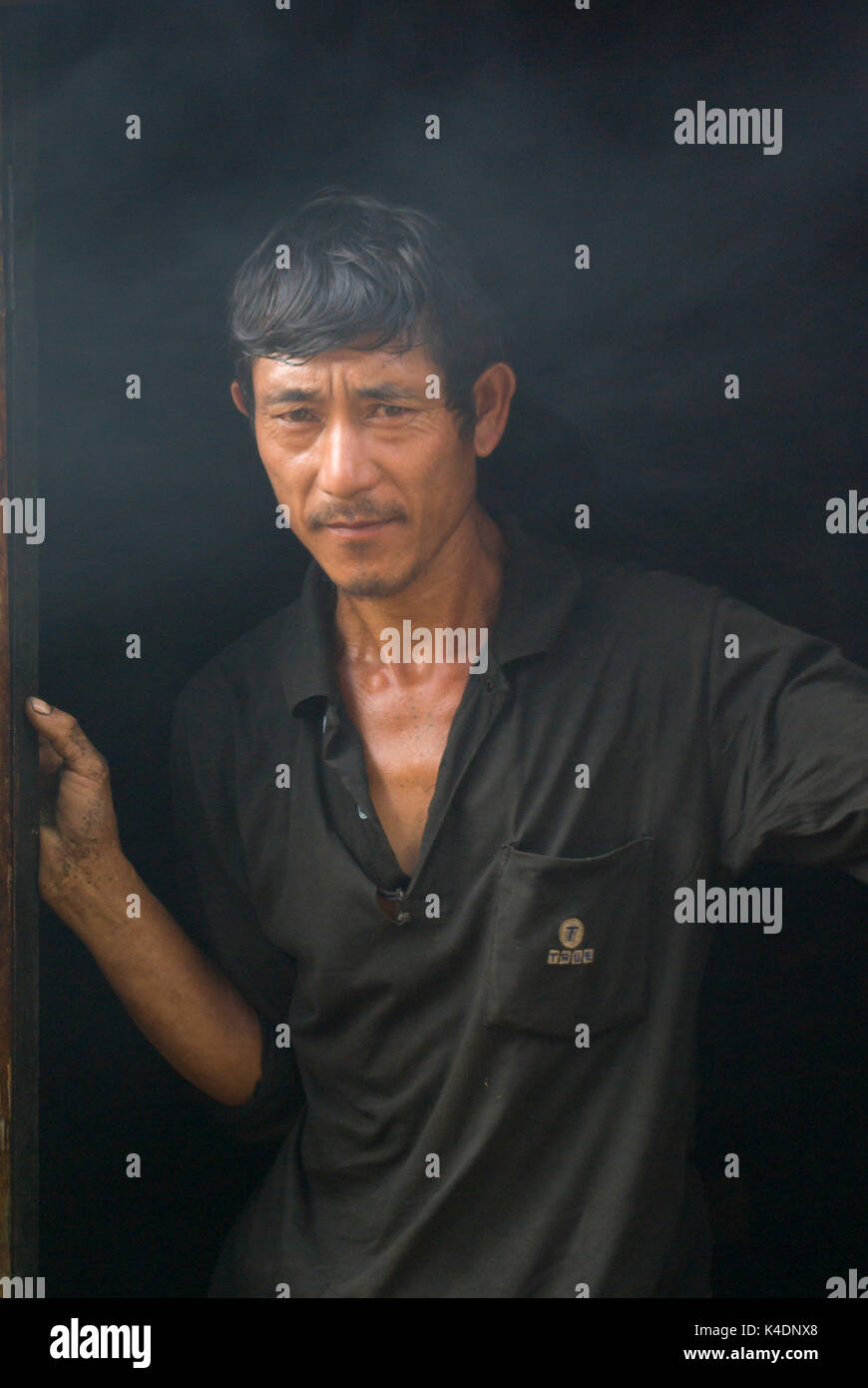 Man standing in doorway in a mountain village, Shan State, Burma ...