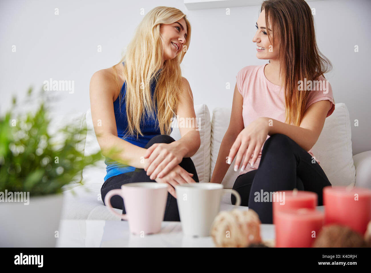 Portrait of two pretty female friends relaxing at home talking Stock ...