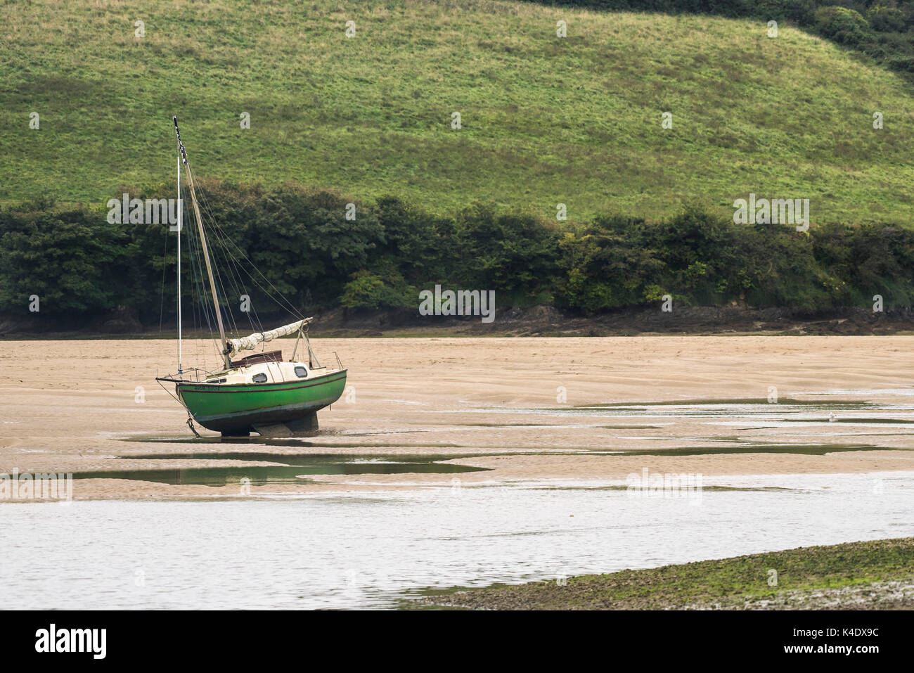 Gannel Estuary - a sailboat moored on the Gannel River at low tide in ...
