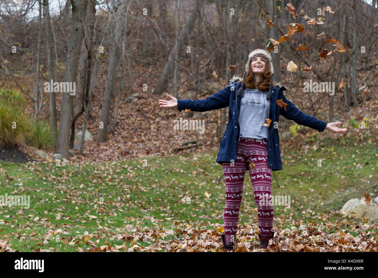 Autumn leaves falling on happy young woman in forest Stock Photo - Alamy
