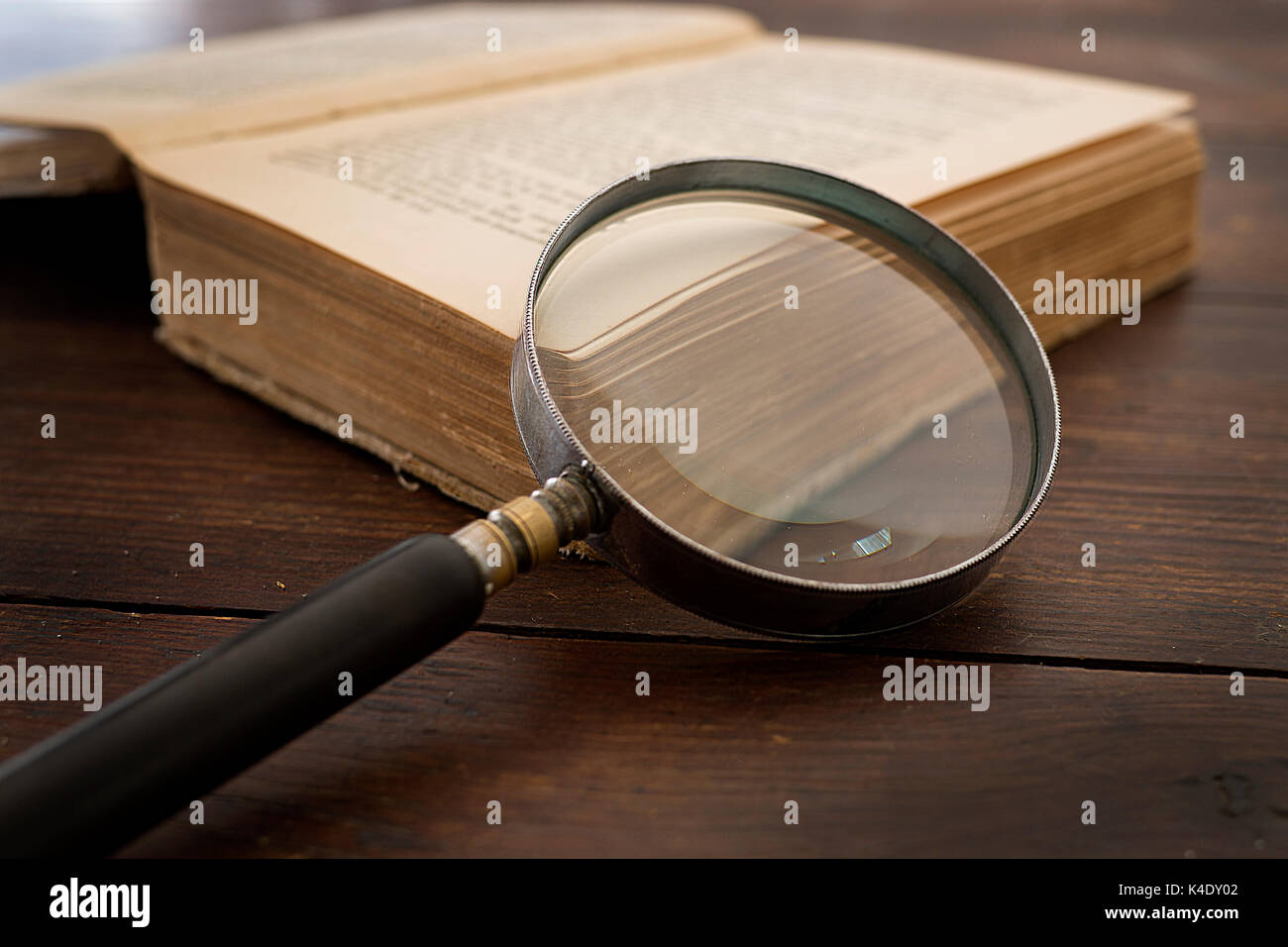Magnifying glass and old book Stock Photo - Alamy