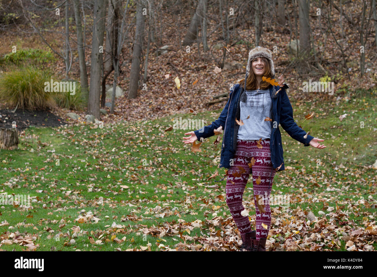 Autumn leaves falling on happy young woman in forest Stock Photo - Alamy