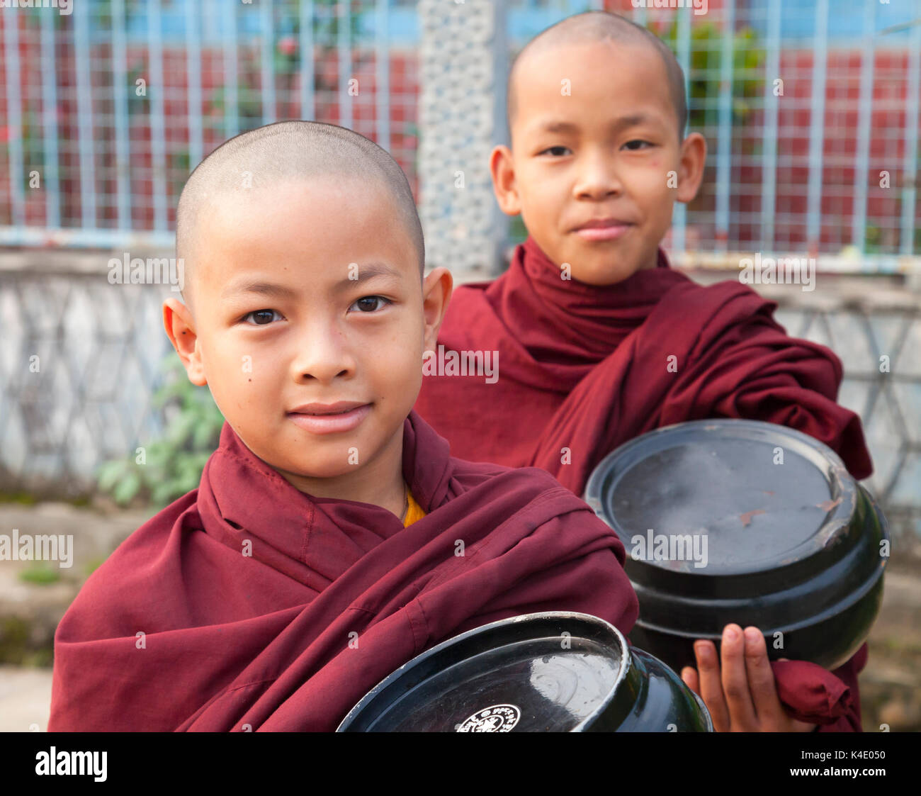 Young Buddhist monks in crimson robes collecting alms in Hsipaw ...