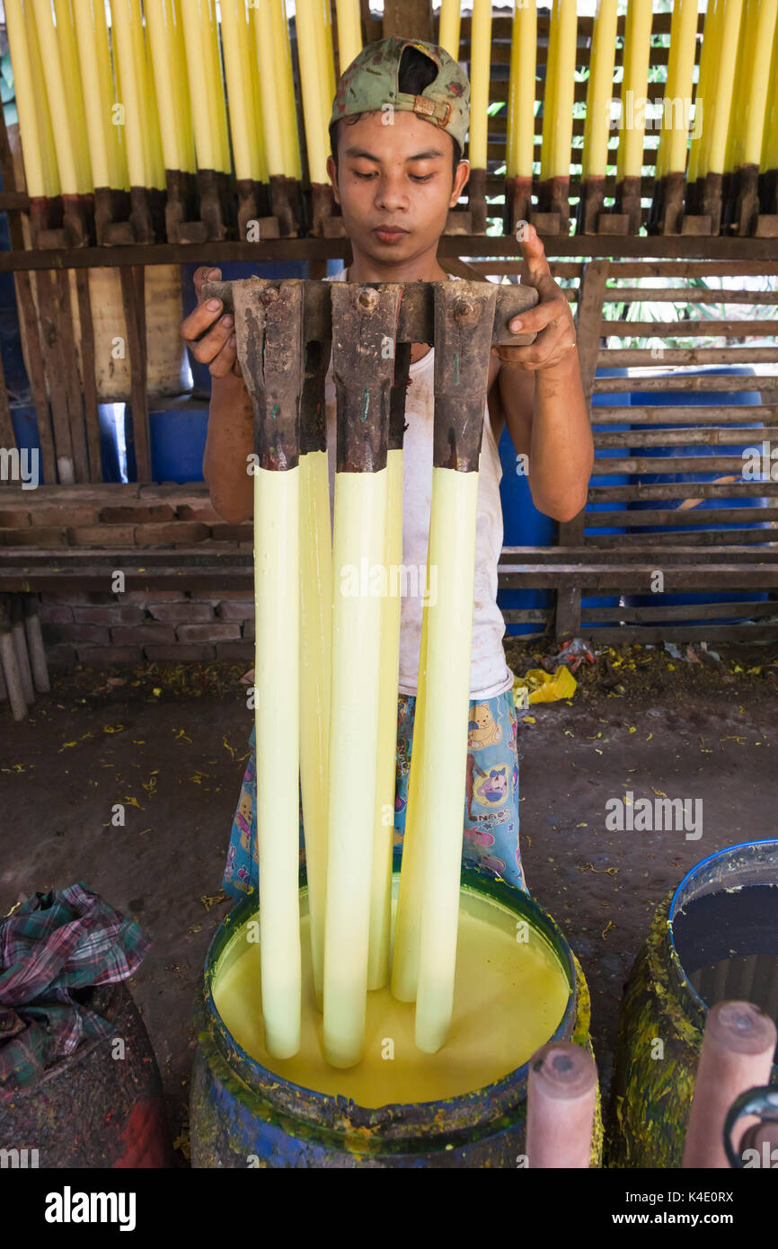 Rubber band factory, Myanmar. Wooden mandrels dipped into dyed latex ...