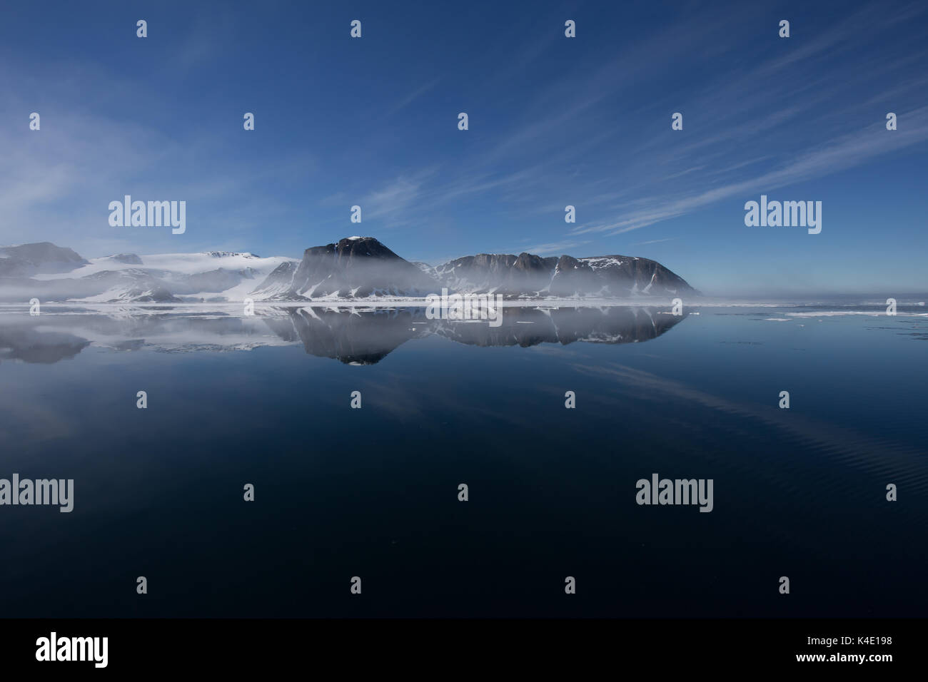 The north coast of the island of Spitsbergen, Svalbard reflected in the ...