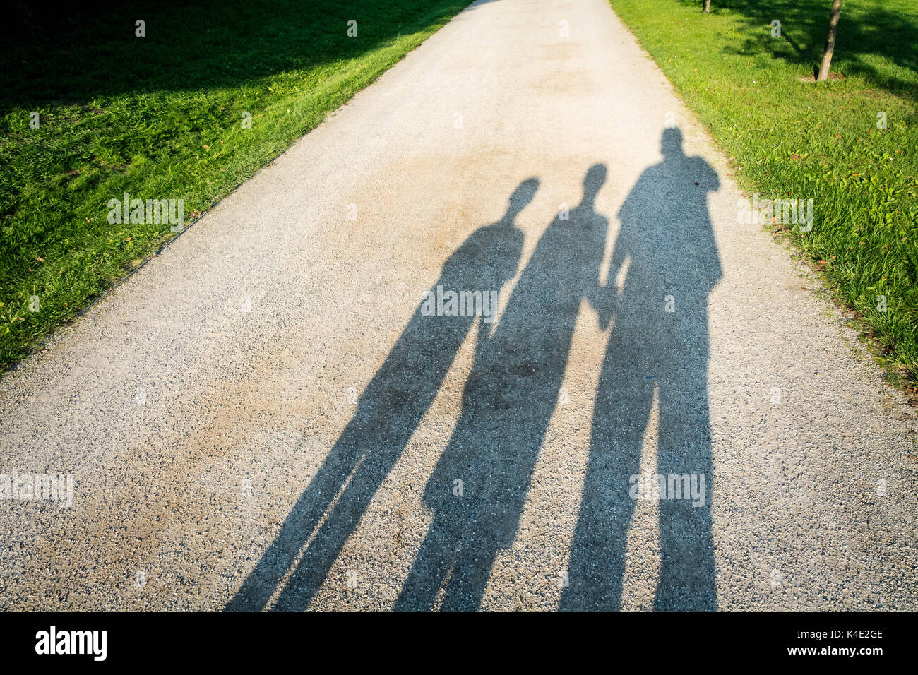 Three Shadows Holding Hands On A Way Stock Photo - Alamy