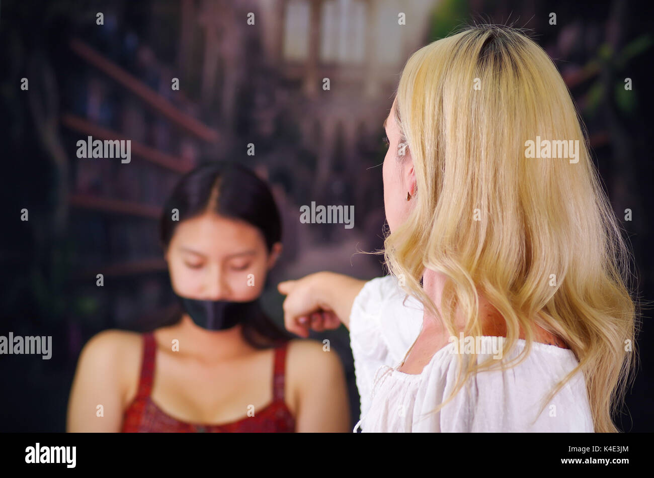 Young mad american blonde woman, exhorting to a latin woman to leave ...