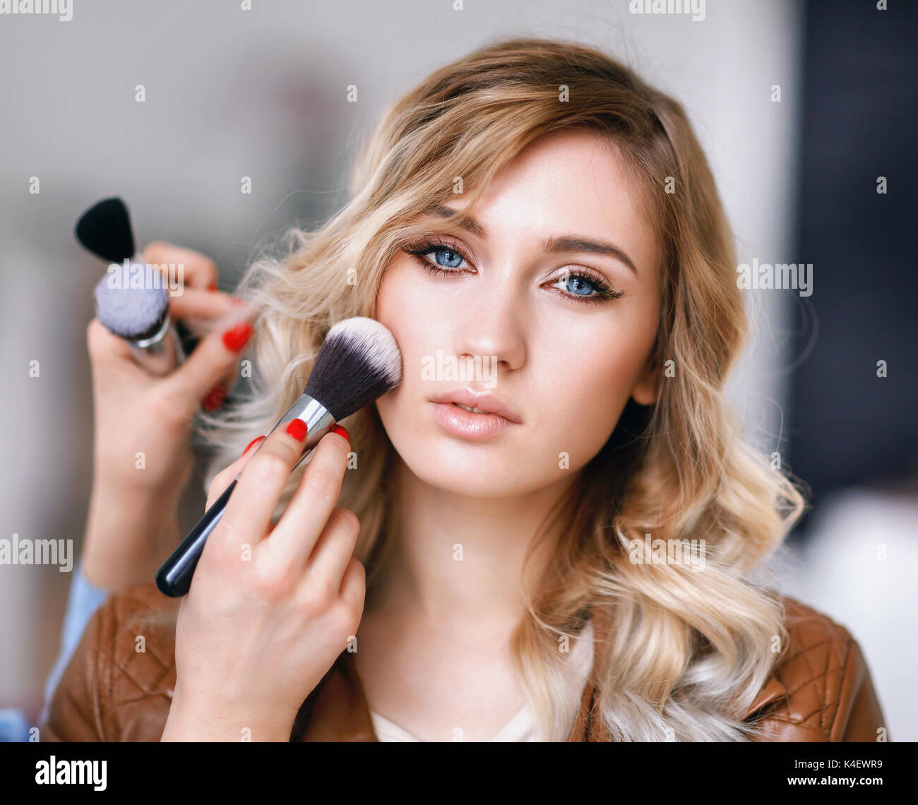 Process of applying makeup on the girl's face close-up. Model is ...