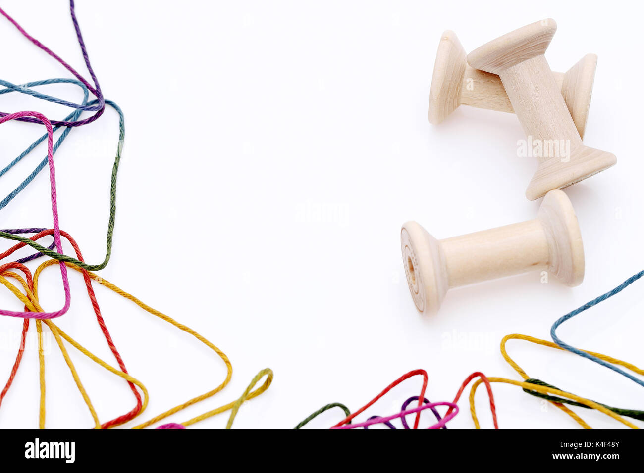 colorful threads and wooden spool on white background Stock Photo - Alamy
