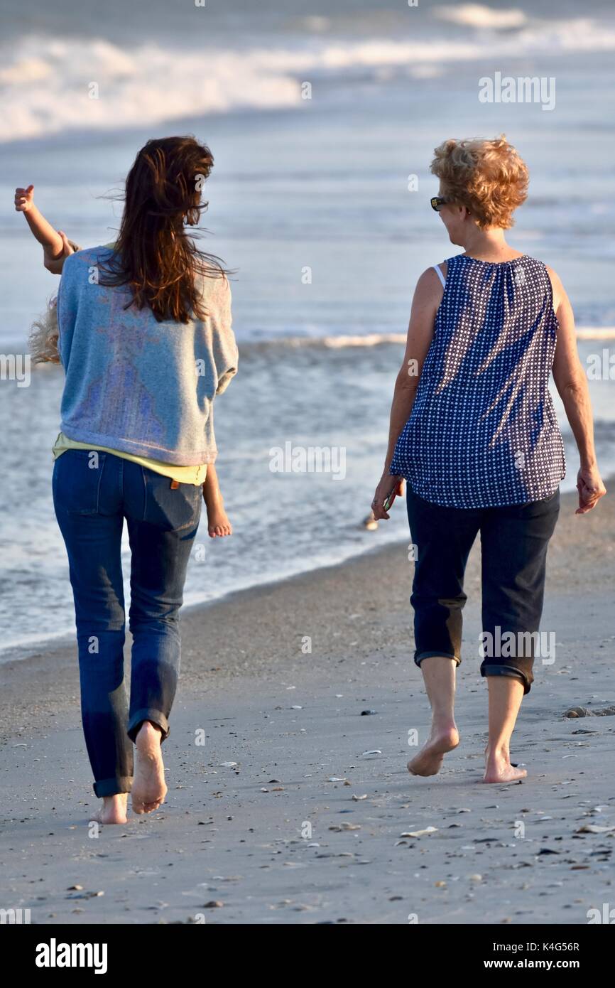 Family walking down ocean beach Stock Photo - Alamy