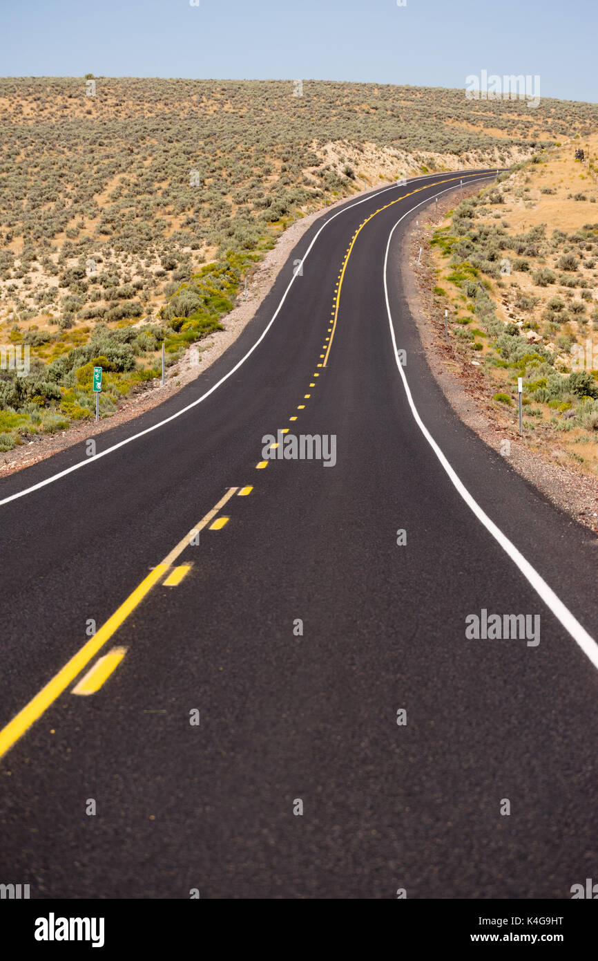 Two Lane yellow line curve around the bend Stock Photo - Alamy