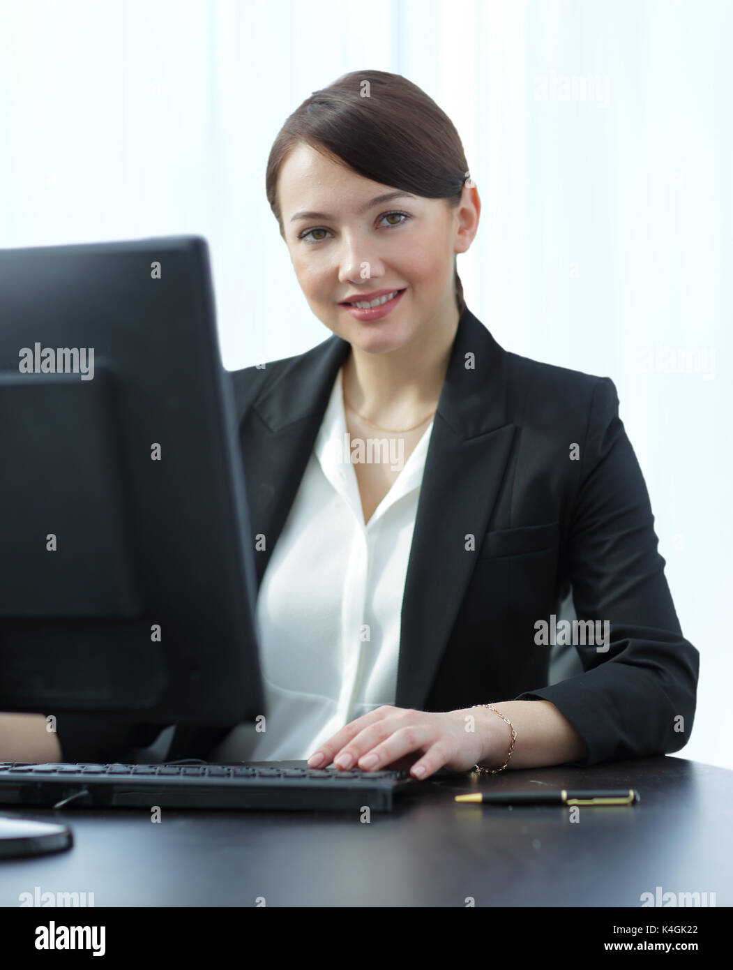 Happy businesswoman typing on computer at her desk Stock Photo - Alamy