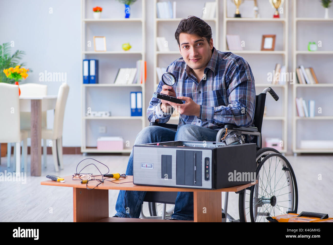 Computer repairman on wheelchair working Stock Photo - Alamy