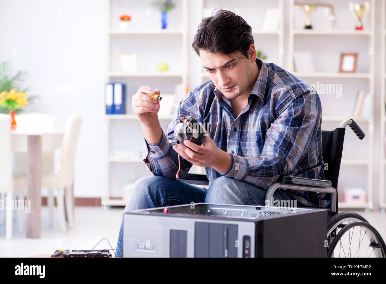 Disabled man on wheelchair repairing computer Stock Photo - Alamy