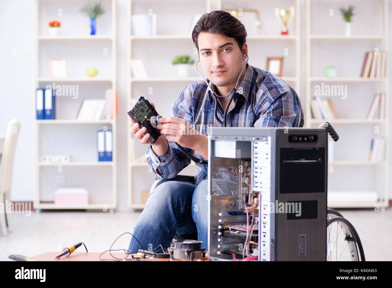 Disabled man on wheelchair repairing computer Stock Photo - Alamy