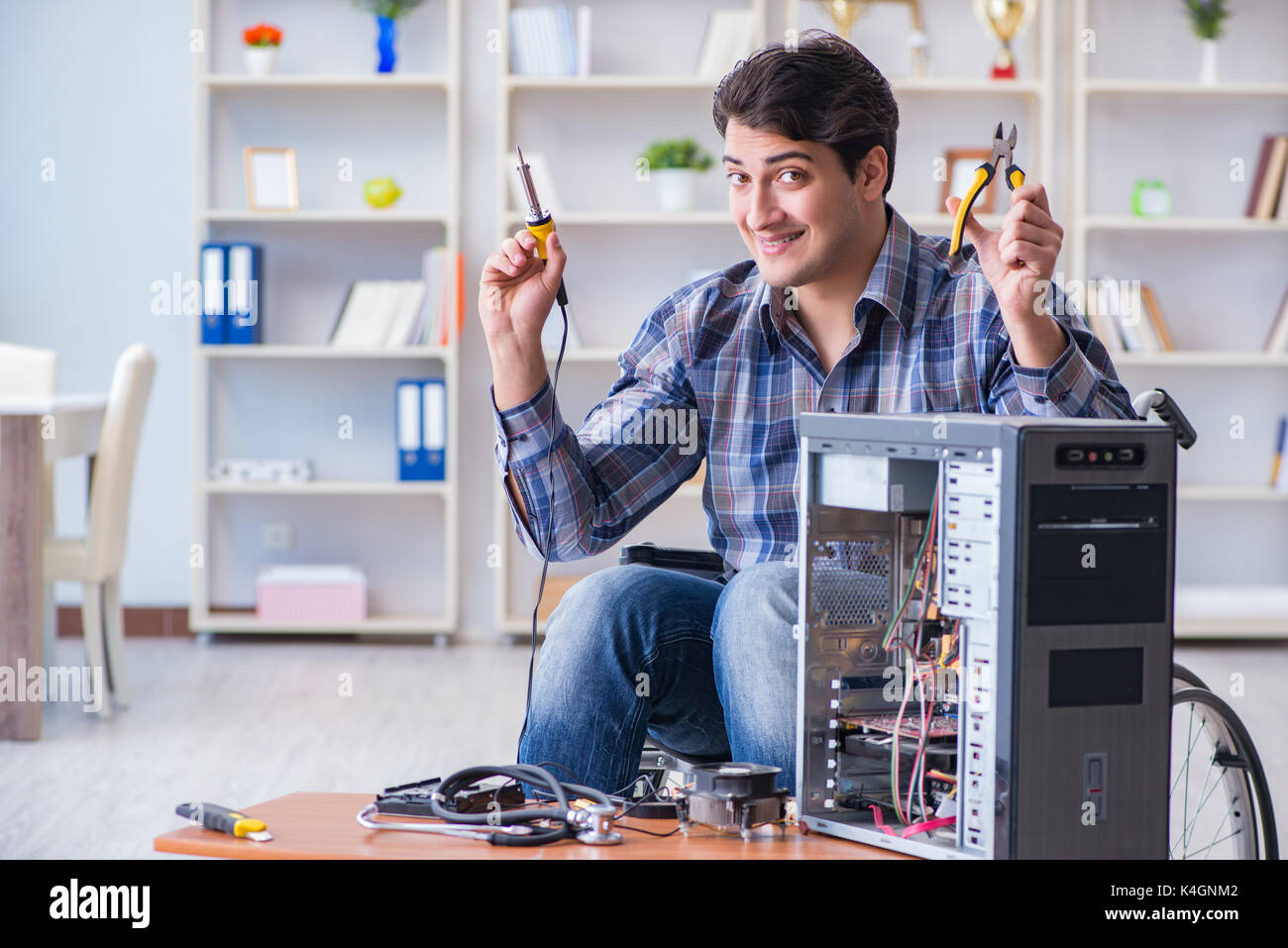 Computer repairman on wheelchair working Stock Photo - Alamy