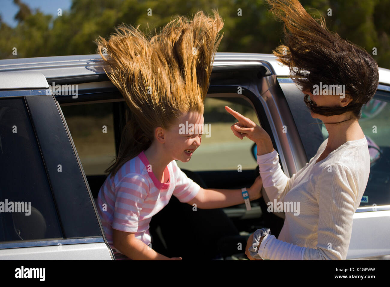A mother and daughter experience high winds next to their vehicle in ...