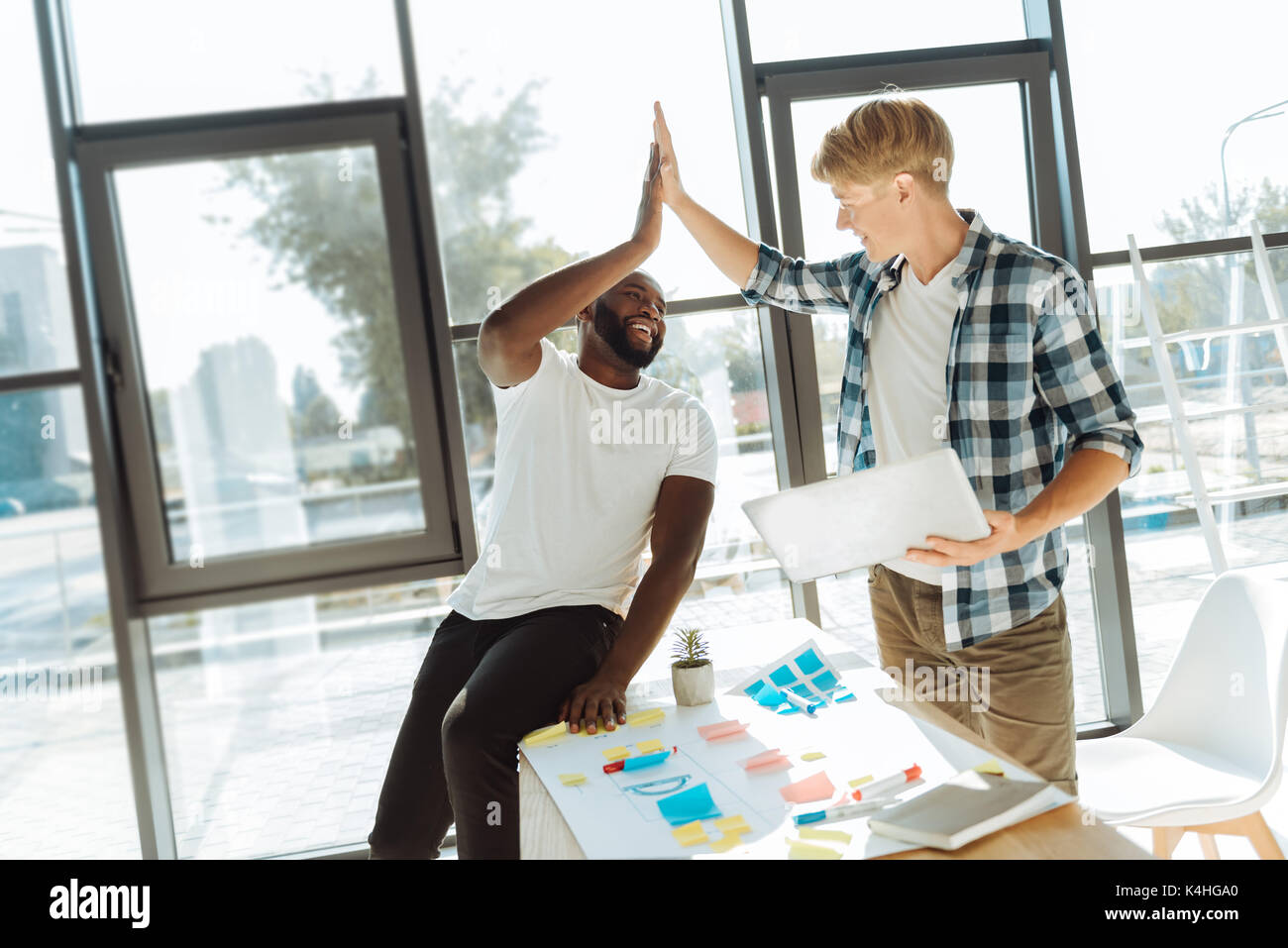 Positive colleagues giving high five Stock Photo - Alamy