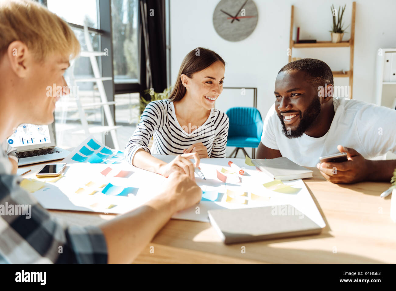 Positive young people talking in the office Stock Photo - Alamy