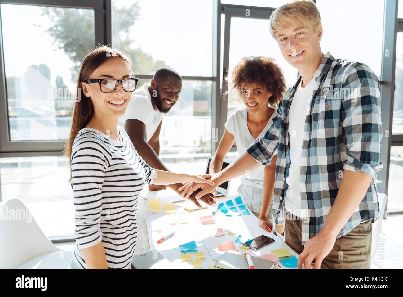 Cheerful friendly colleagues holding hands together Stock Photo - Alamy