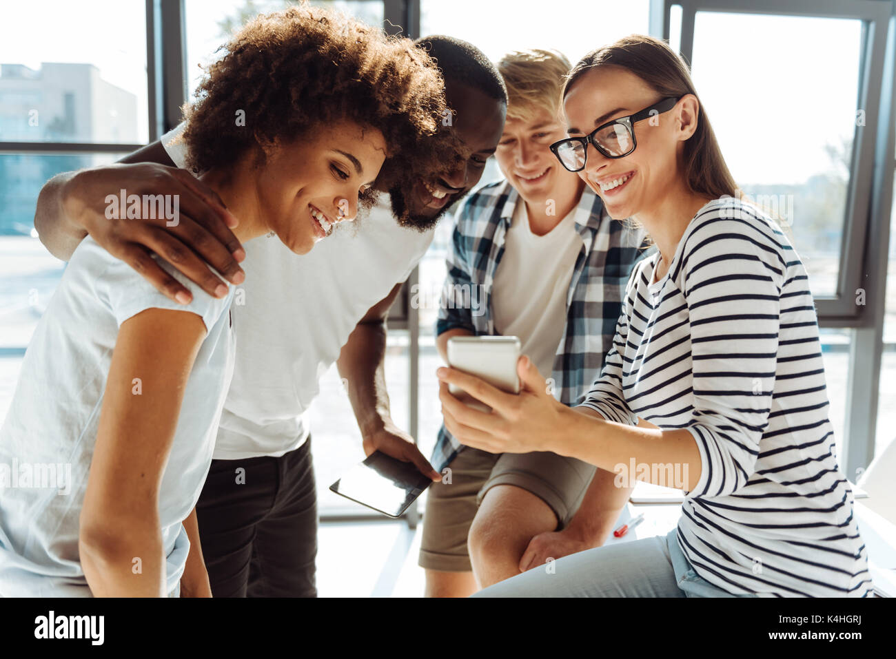 Joyful students using smart phone Stock Photo - Alamy