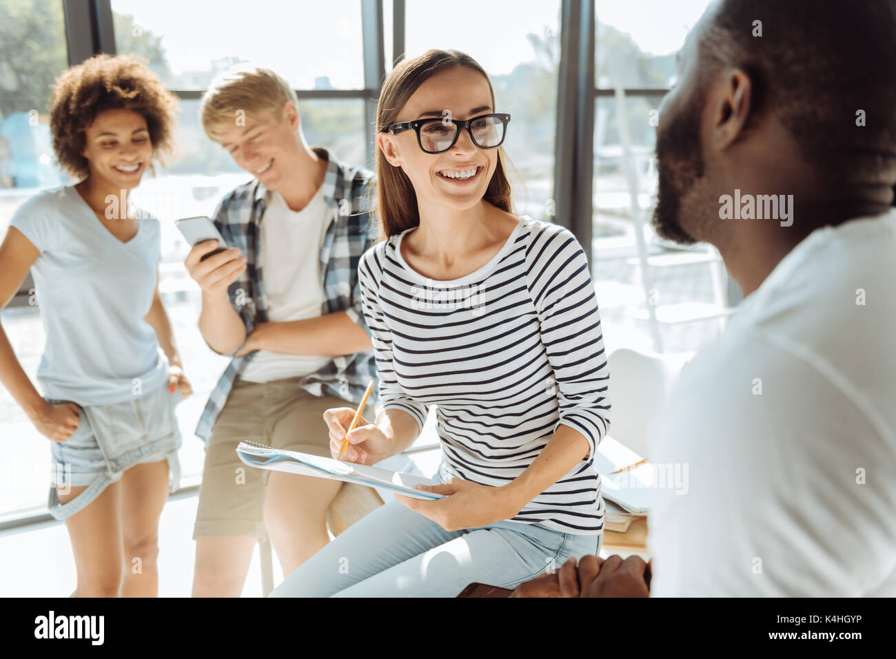 Positive international students talking together Stock Photo - Alamy