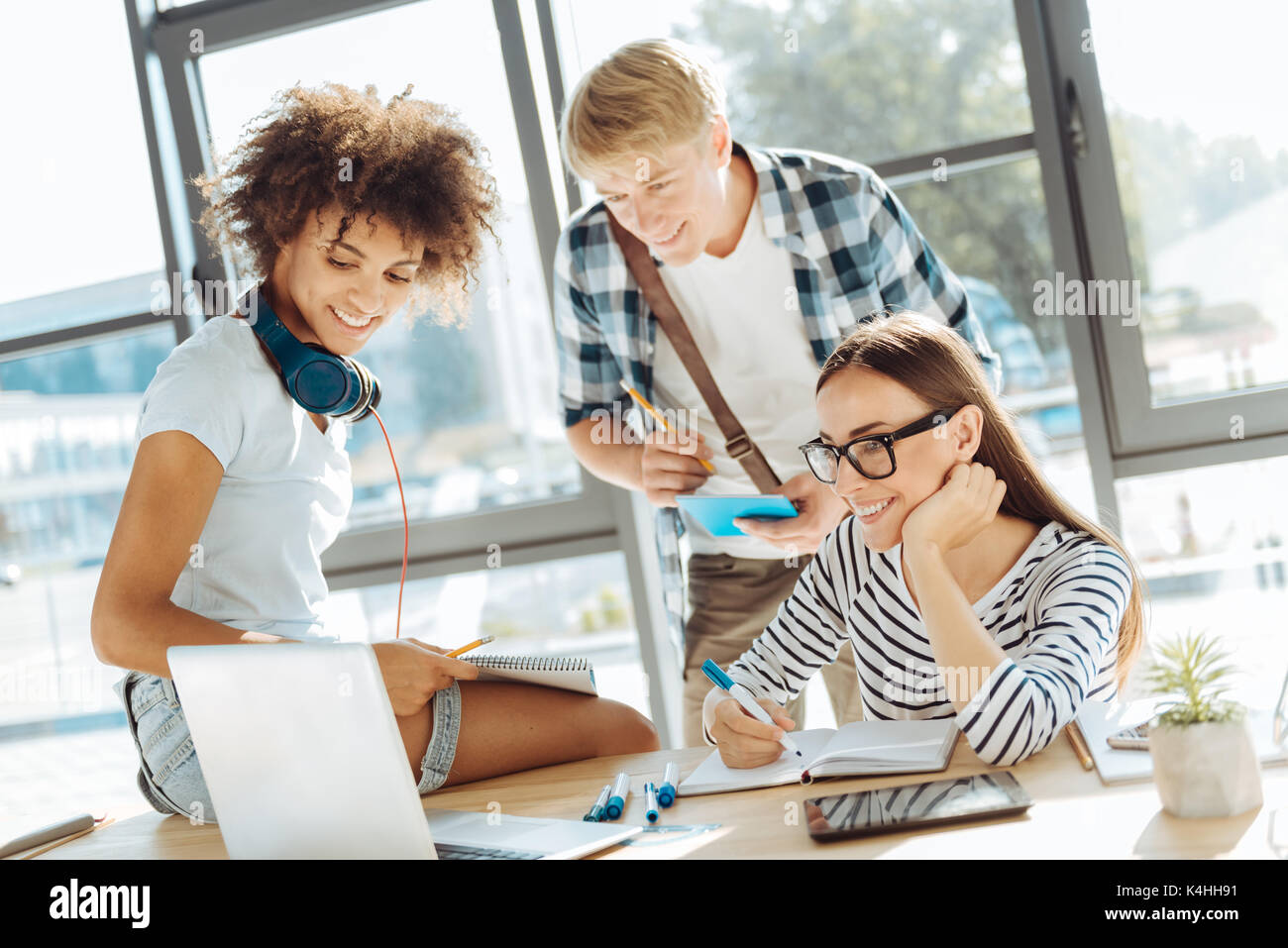 Positive young students studying together Stock Photo - Alamy