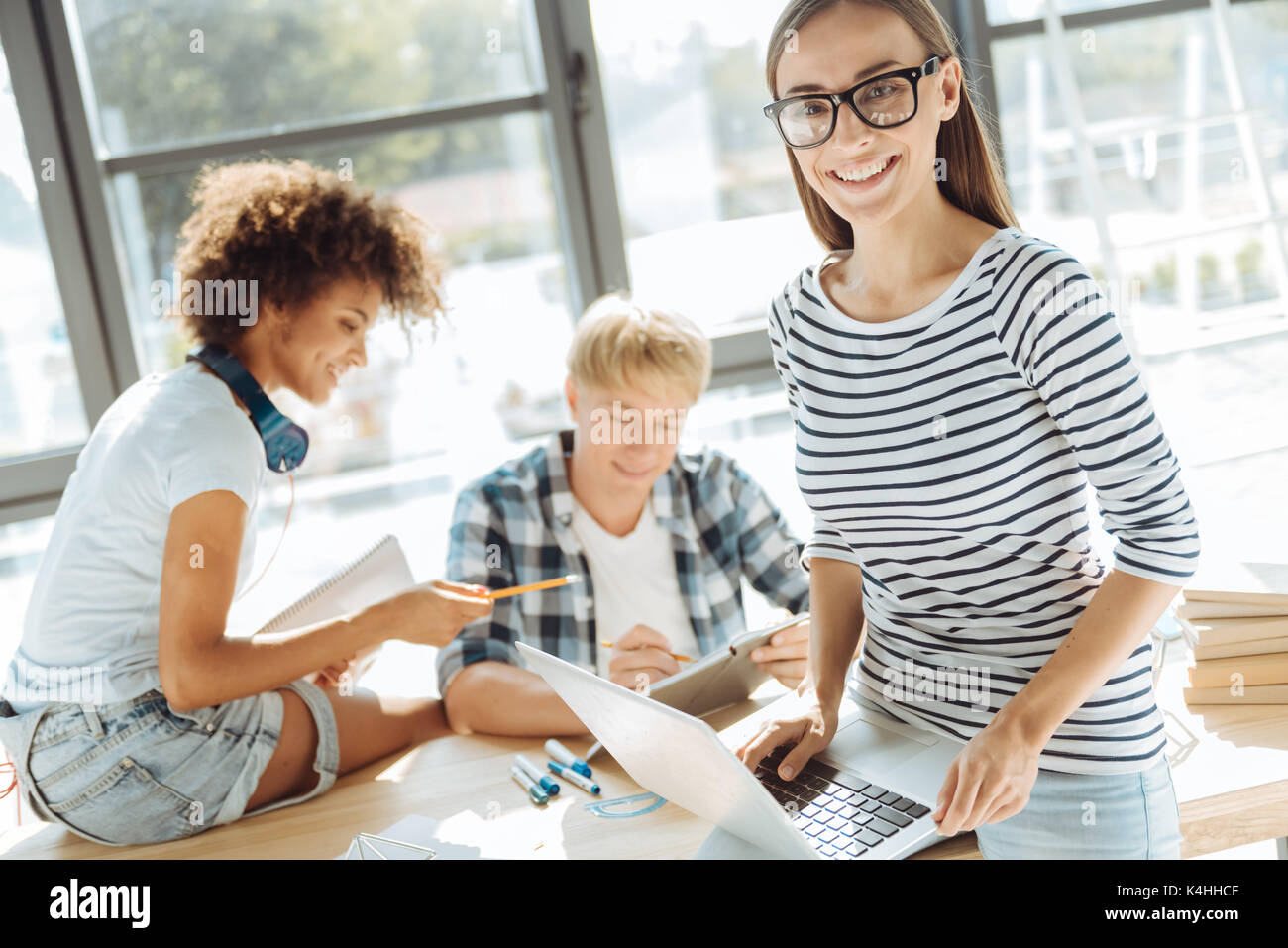 Positive attractive woman studying with her groupmates Stock Photo - Alamy