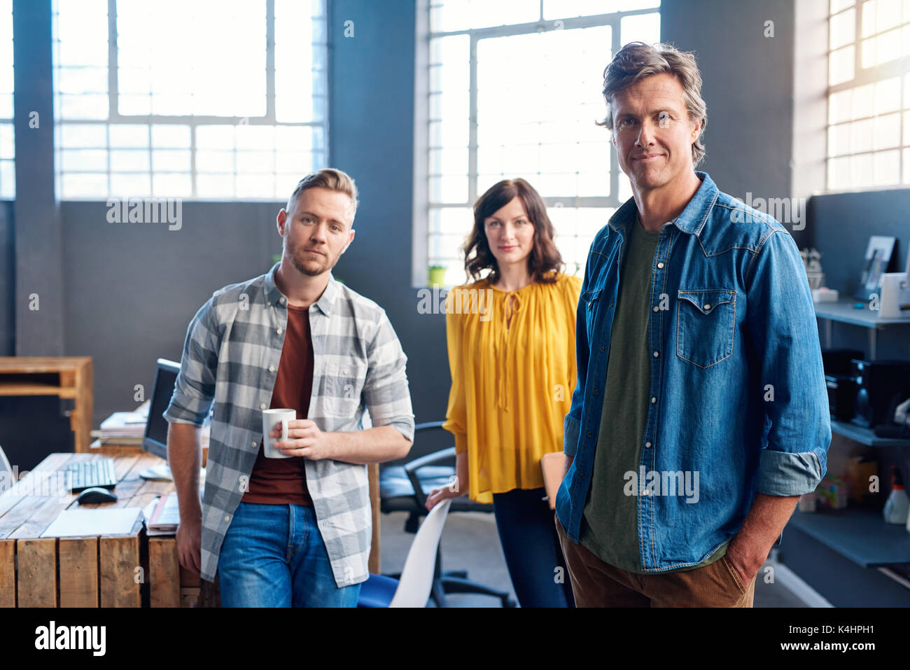 Three professionals working modern office space hi-res stock ...